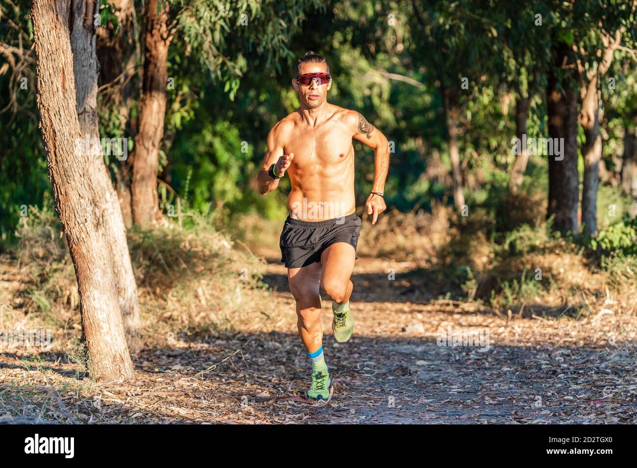 Full body of serious active sportsman in sunglasses running fast on ...
