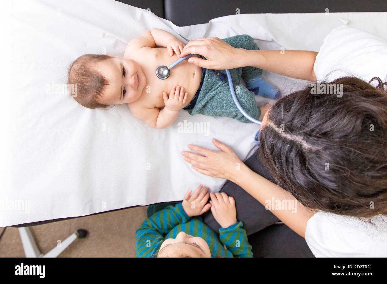 Little beautiful baby having a medical examination by a Woman ...
