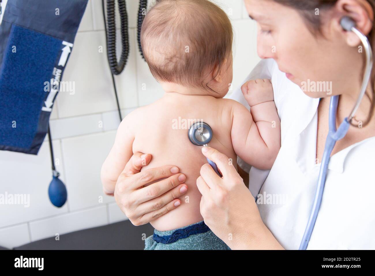 Little beautiful baby having a medical examination by a Woman ...