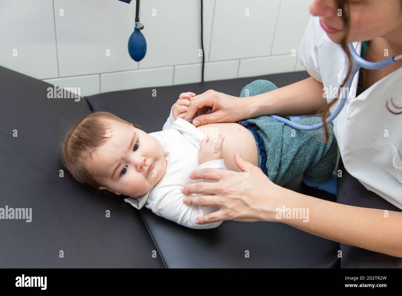 Little beautiful baby having a medical examination by a Woman ...