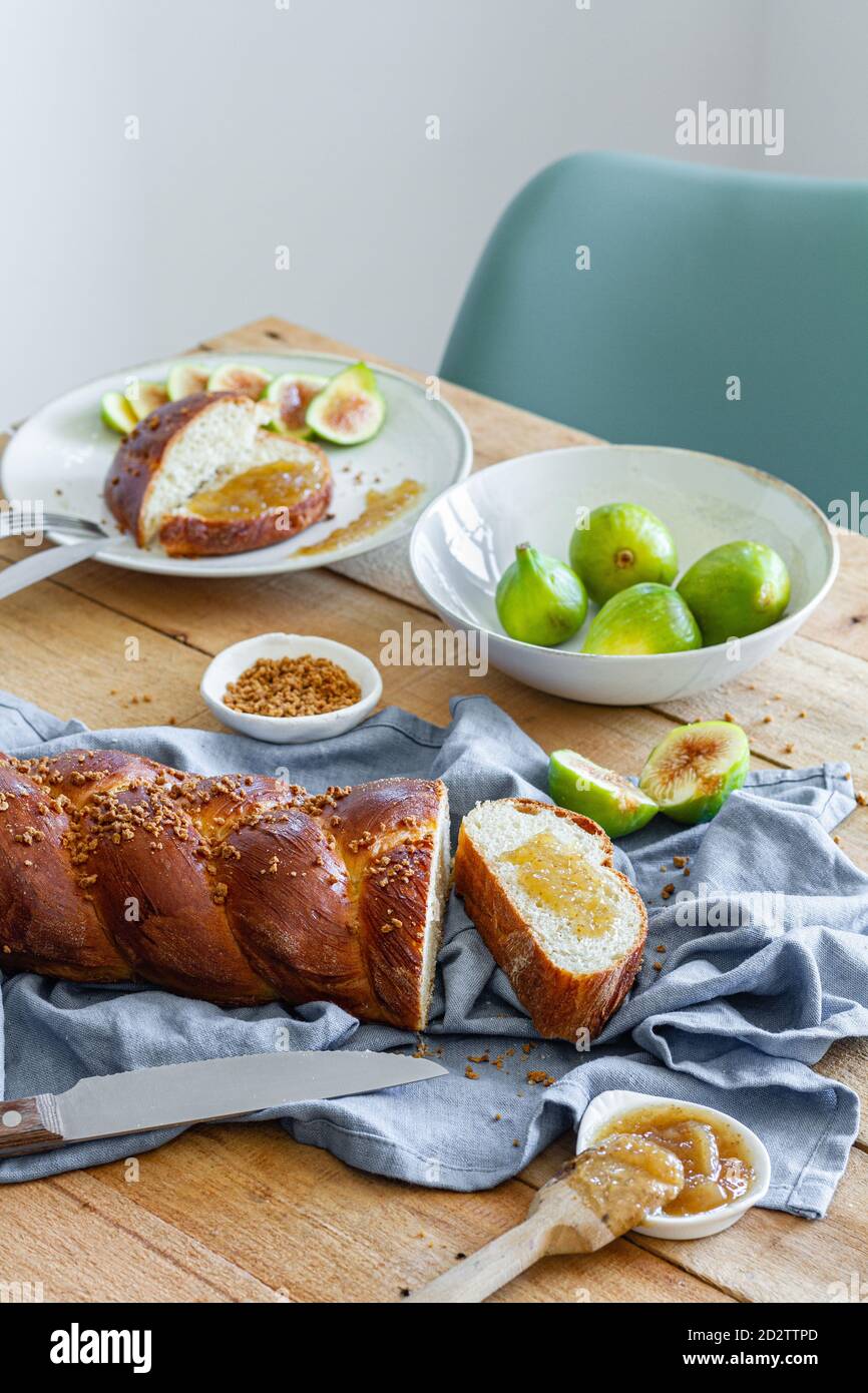 Top view composition of sliced braided bread served with fresh figs and ...