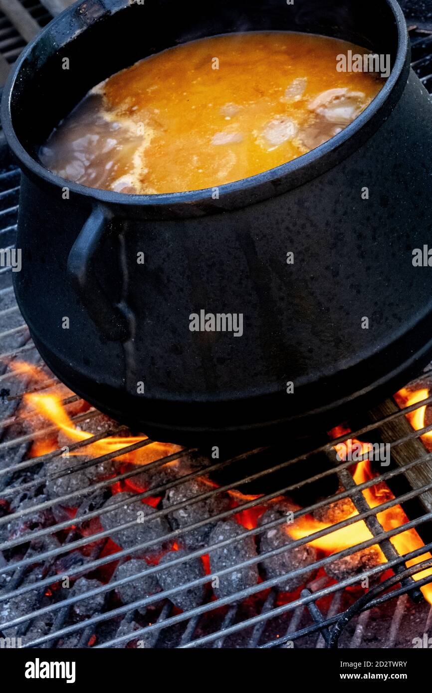 Stew cooked on fire outdoors in a cast-iron pot, coal fire Stock Photo ...