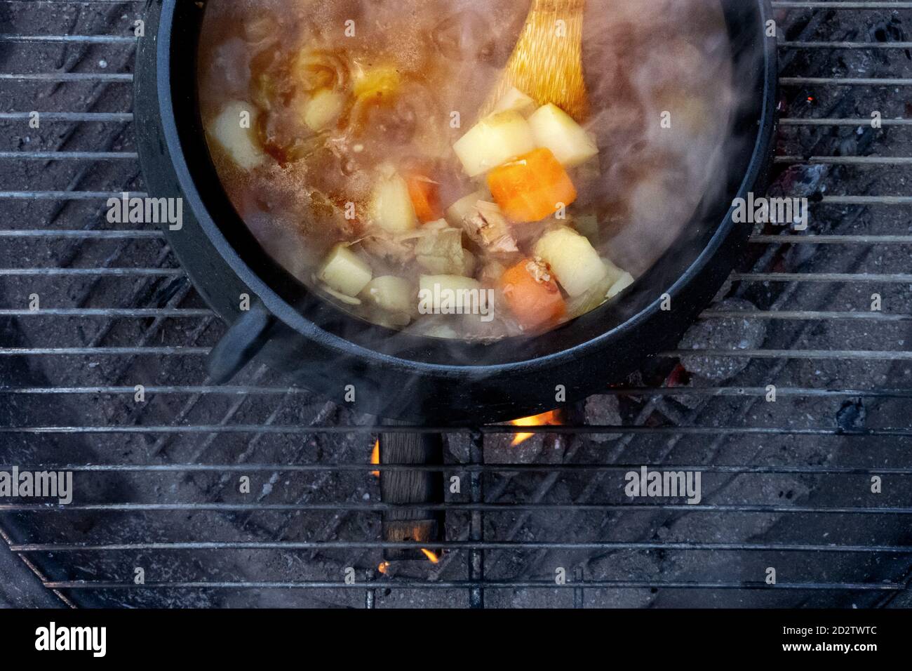 Stew cooked on fire outdoors in a cast-iron pot, overhead shot Stock ...