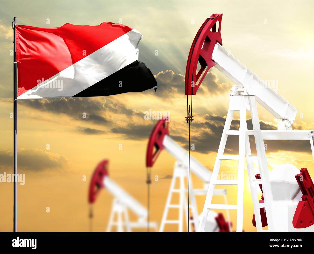 Oil rigs against the backdrop of the colorful sky and a flagpole with ...