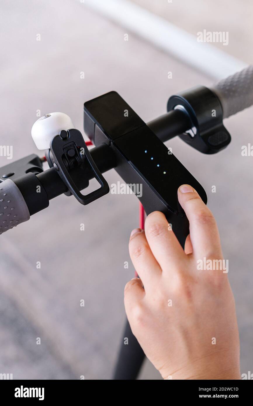 Crop anonymous rider pressing power button on control panel of electric ...