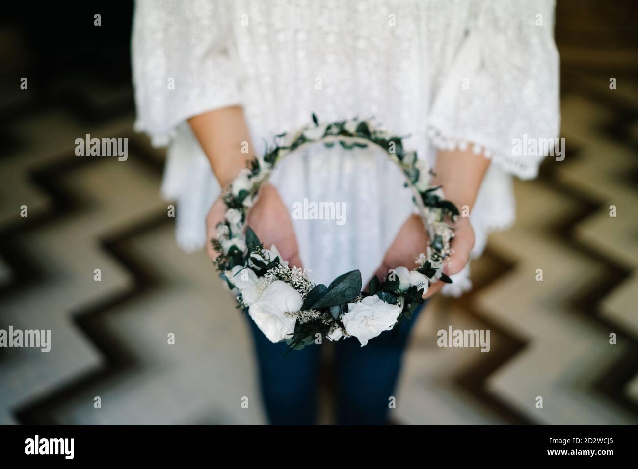 High angle of anonymous female standing with delicate floral wreath ...