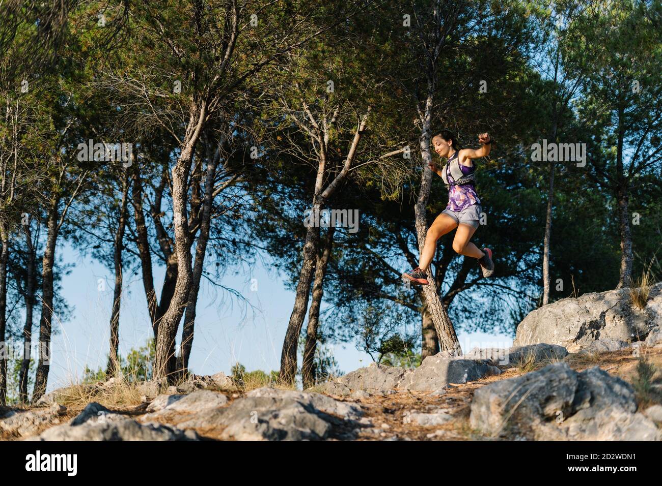 From below side view of active sportive young Woman jumping high over ...