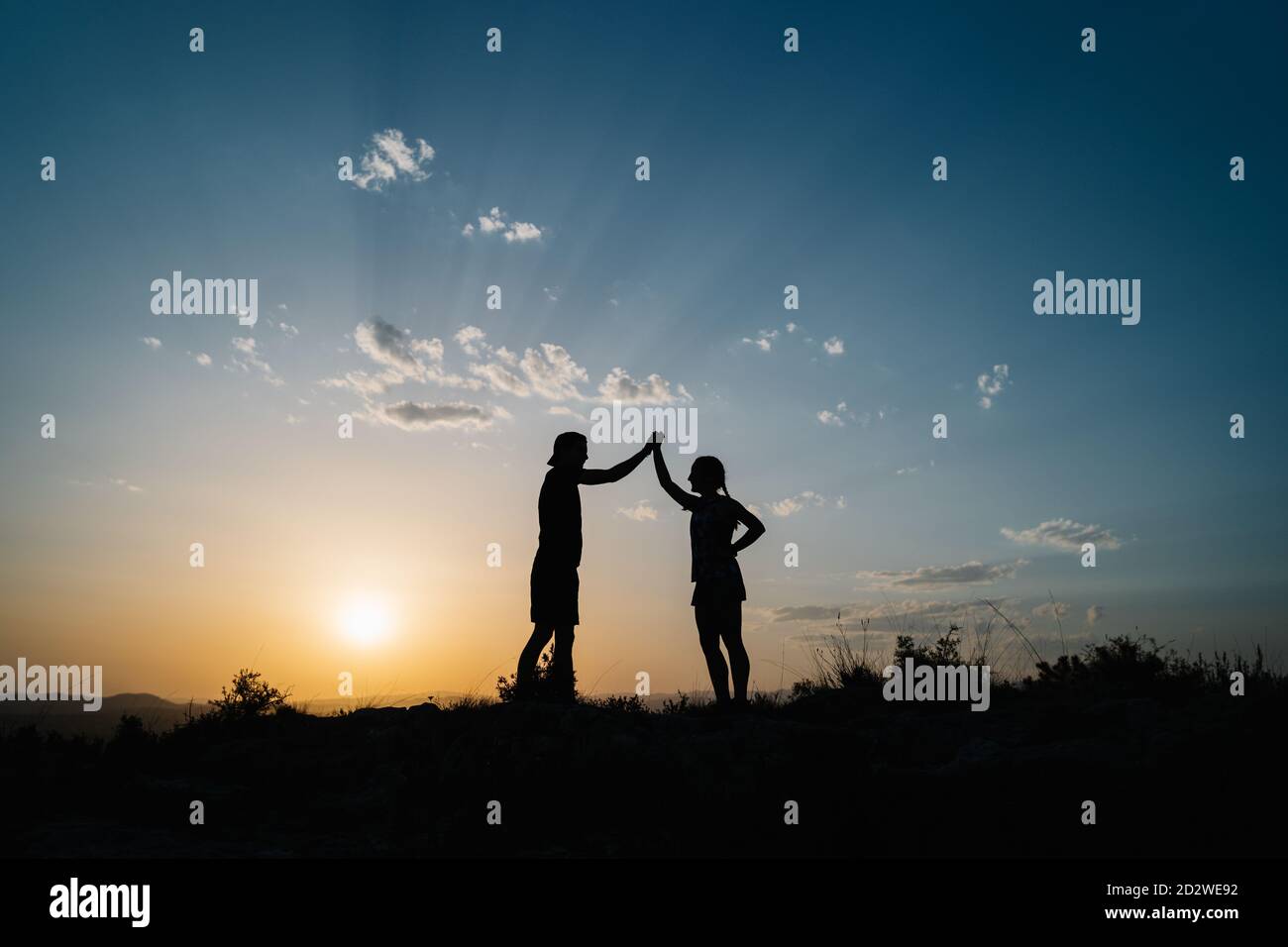 Side view silhouettes of unrecognizable male and female friends high ...