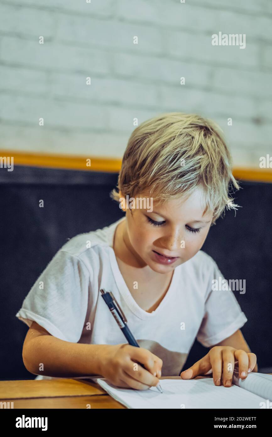 Portrait blond cute Preschool boy holding pen notebook look happy learn ...