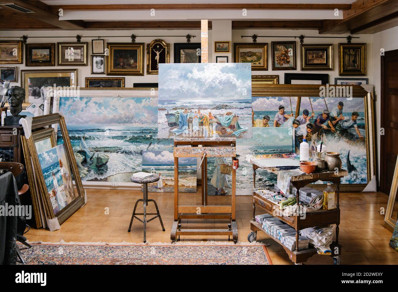 Interior of creative art workshop with painting on easel near shelf ...