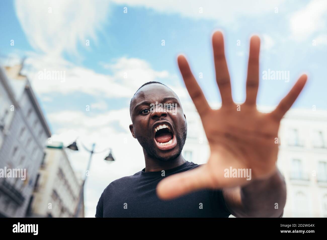 man protesting at a rally for racial equality raising arms showing hand ...