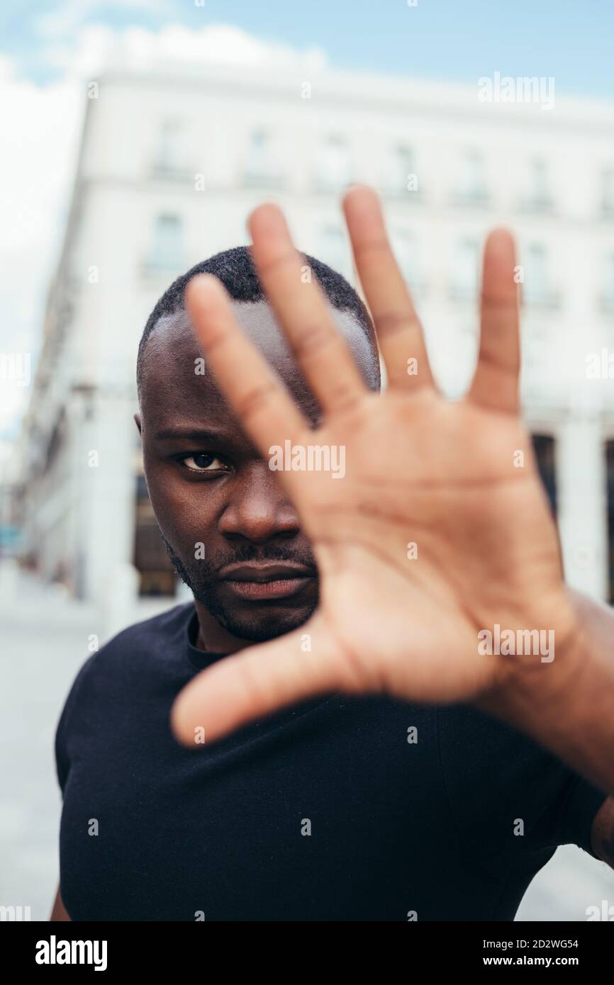 man protesting at a rally for racial equality raising arms showing hand ...