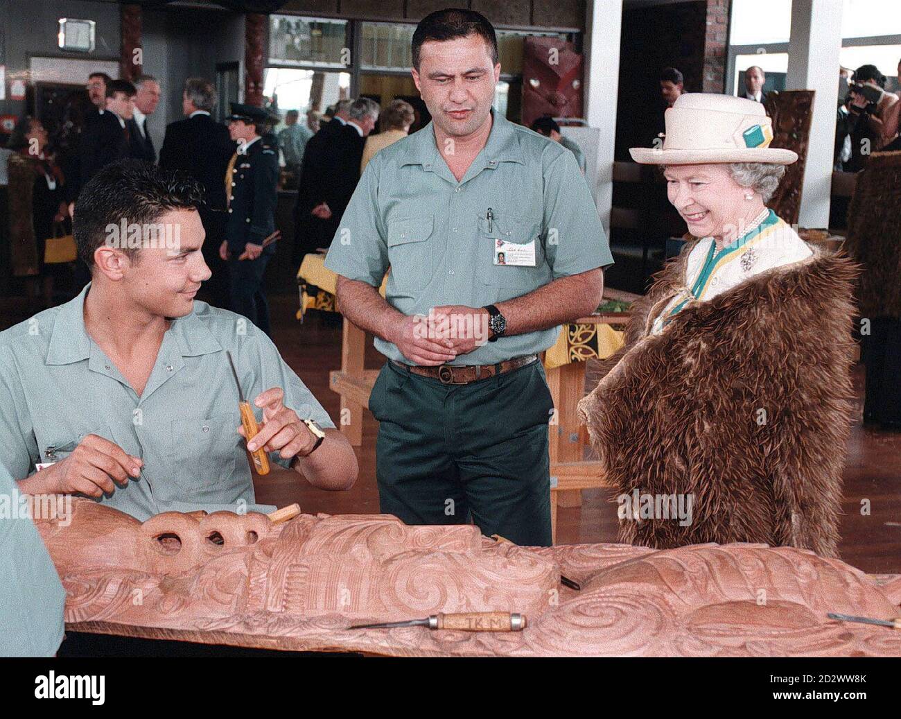 The Queen wearing a kiwi feather Maori cape, inspects the work of the ...