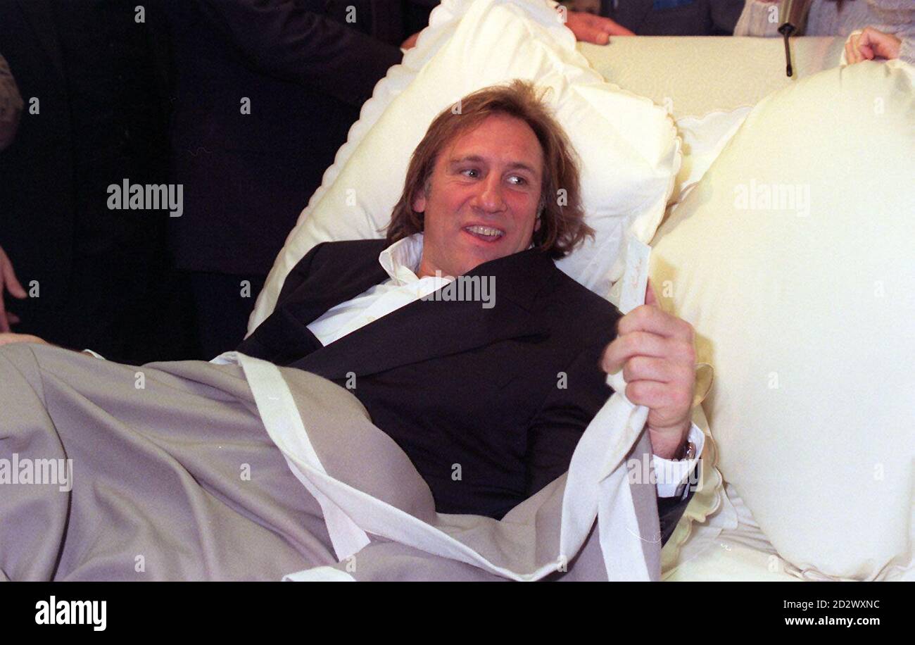 French actor Gerard Depardieu climbs into one of the beds on display in ...