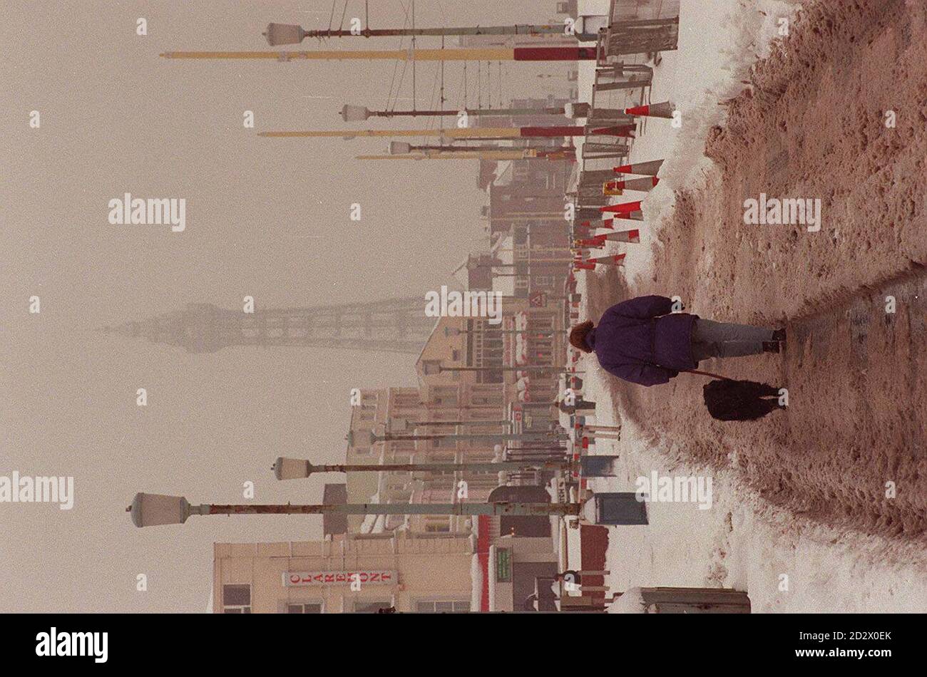A local resident waks along a snow-covered promenade at Blackpool as ...