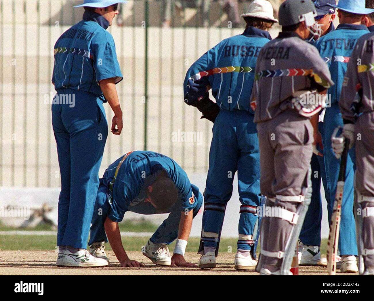 Craig White sits hurt on the wicket after he stopped bowling for ...