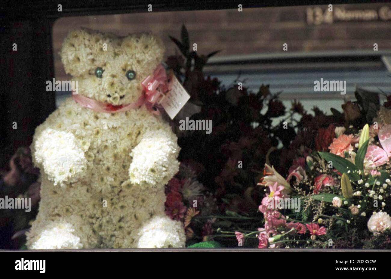 A wreath in the shape of a teddy bear amongst the many floral tributes ...