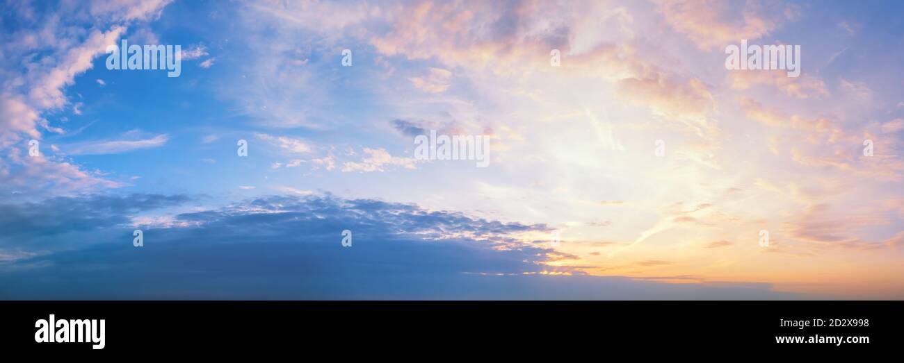 Pastel colored sunset sky long panoramic view. Sun into clouds at ...