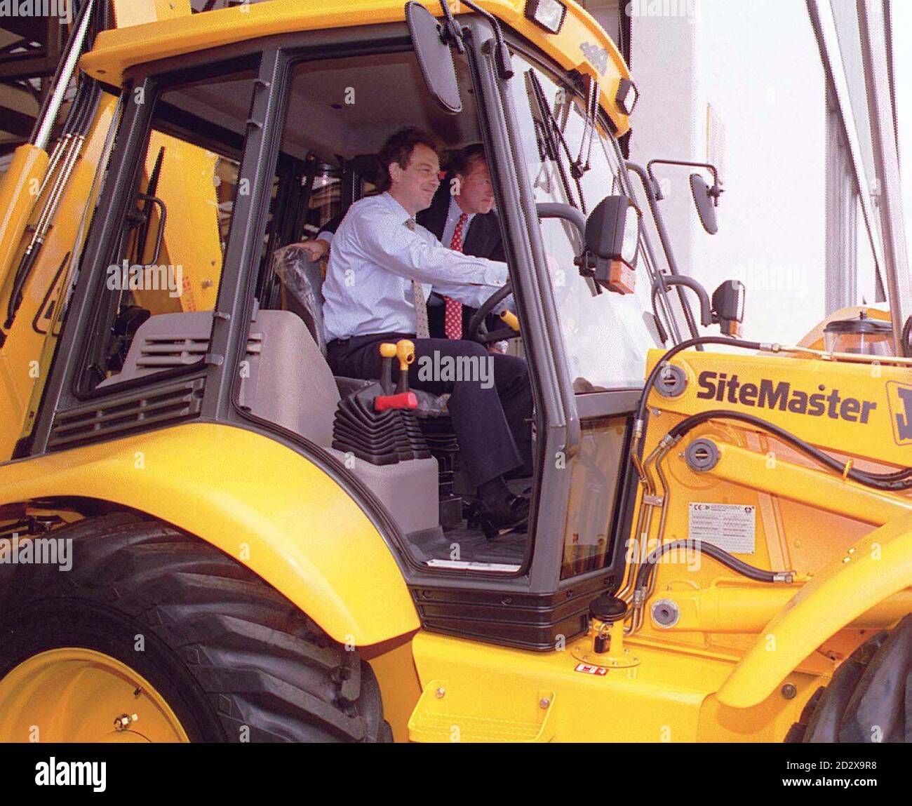 Labour leader Tony Blair drives a JCB Sitemaster from the factory at ...