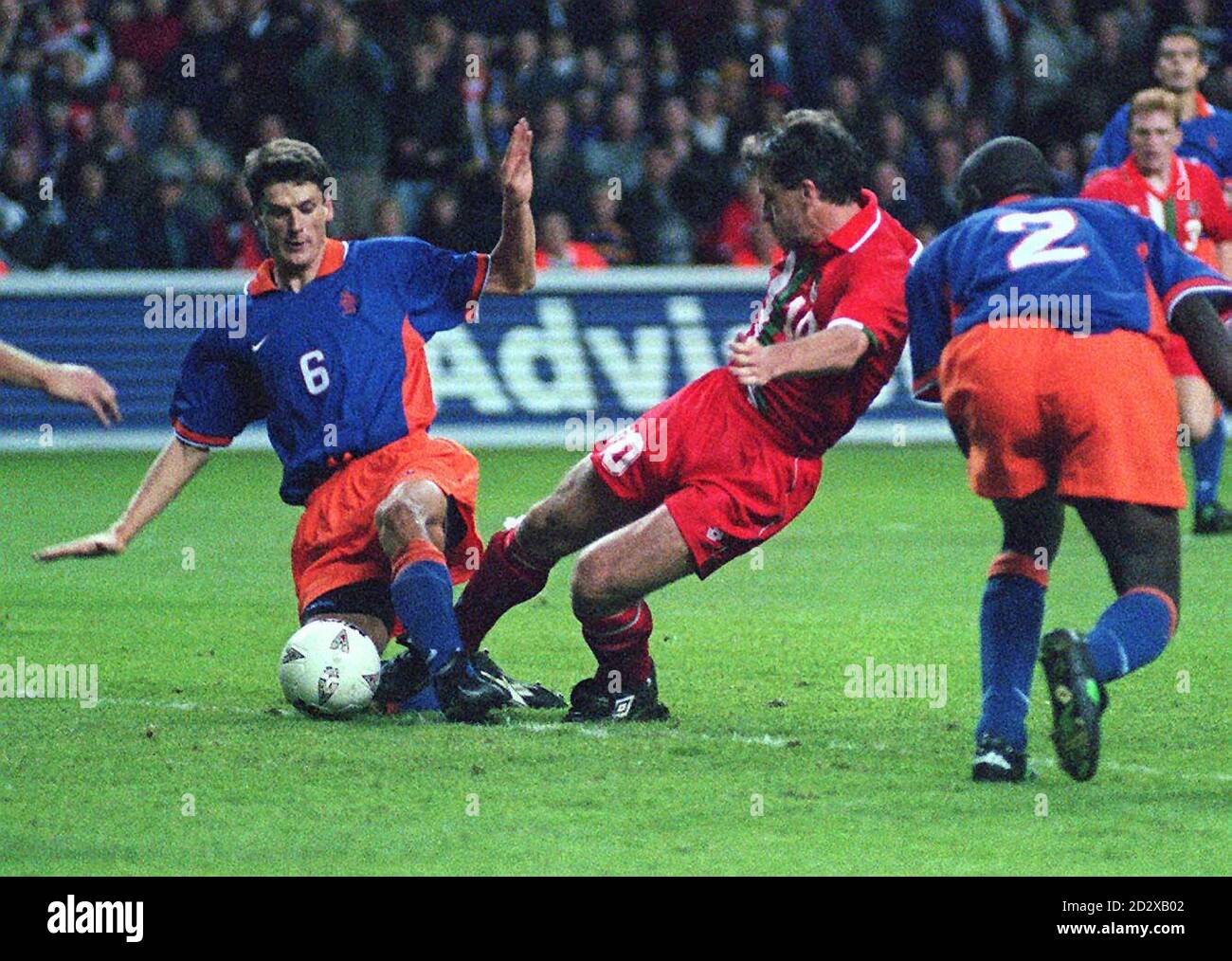 Wales' Mark Hughes (cen) is denied a clean strike by Holland's Wim Jonk ...