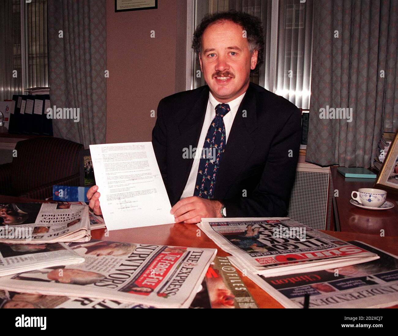 Rick Parry, Chief Executive of football's Premier League, holds up a ...
