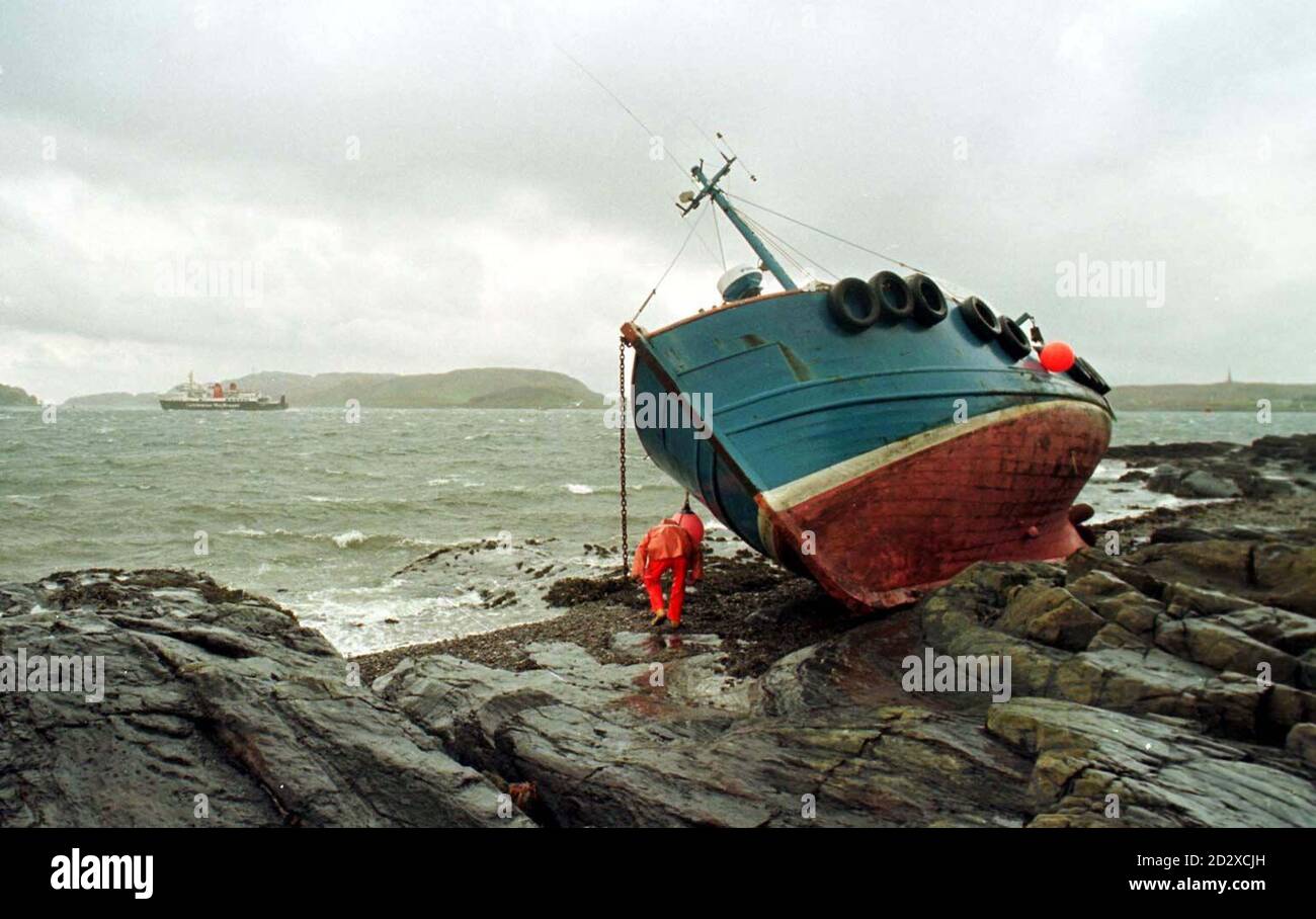 A fishing boat lies on the rocks near the port of Oban after a night of ...