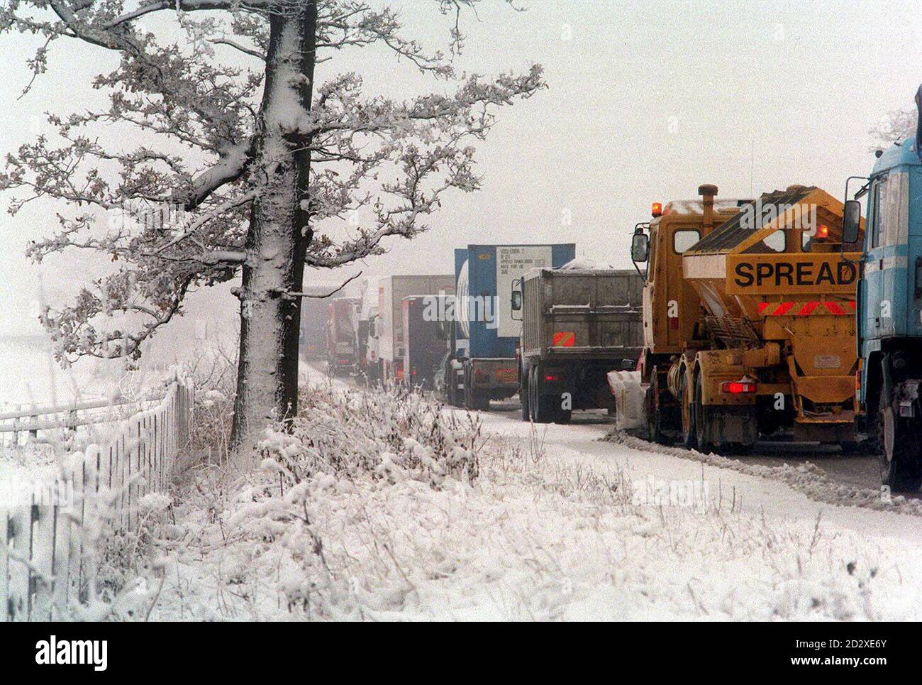 A queue of over 150 vehicles stand trapped in severe snow conditions on ...