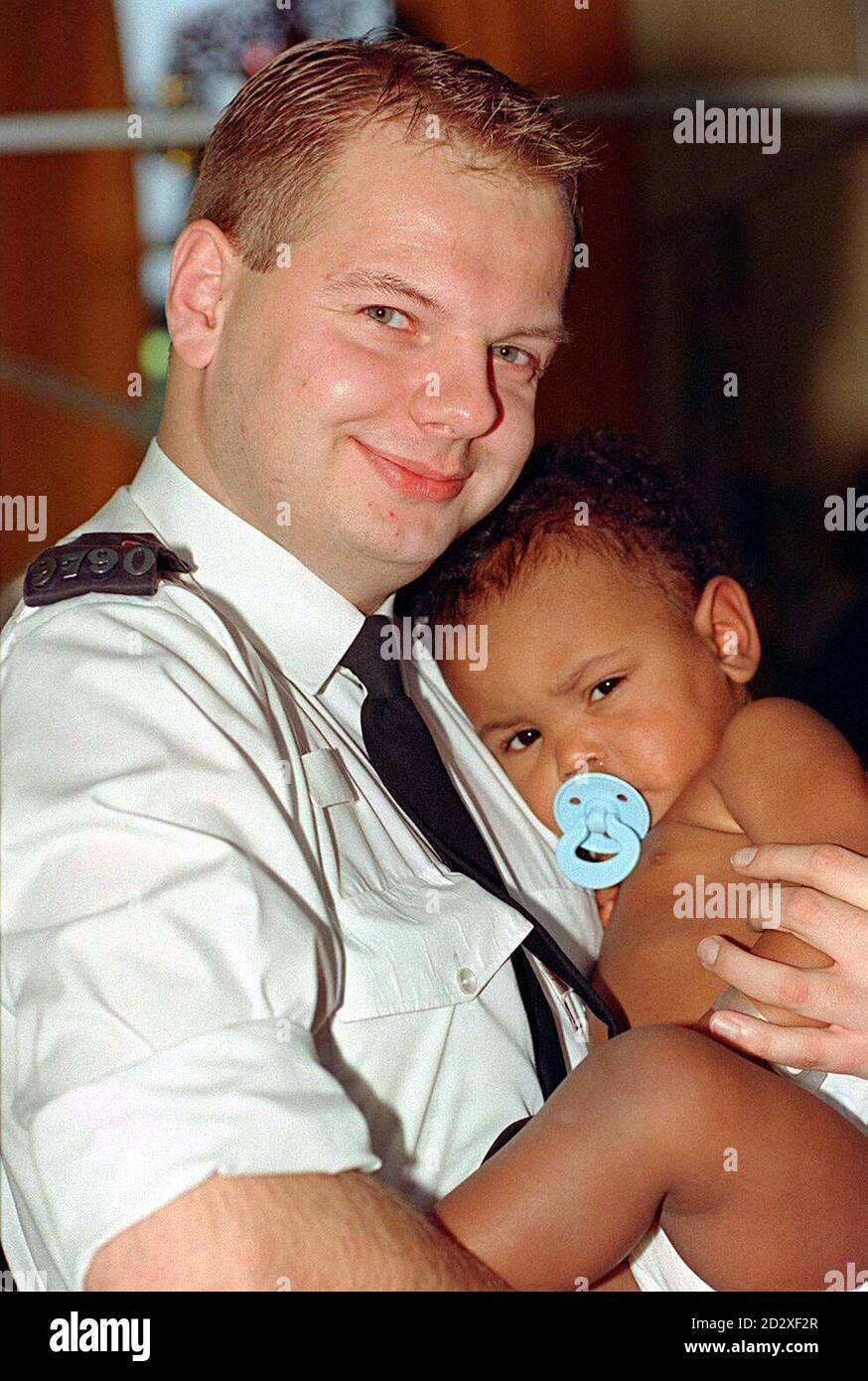 PC Simon Hale with 19 month old Reshaun Edwards in Birmingham today ...