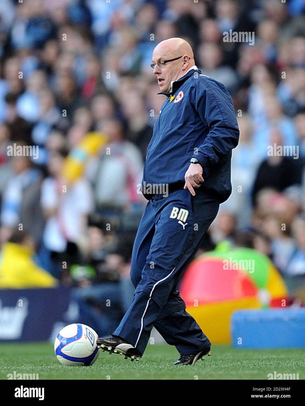 Reading manager Brian McDermott controls the ball on the touchline ...