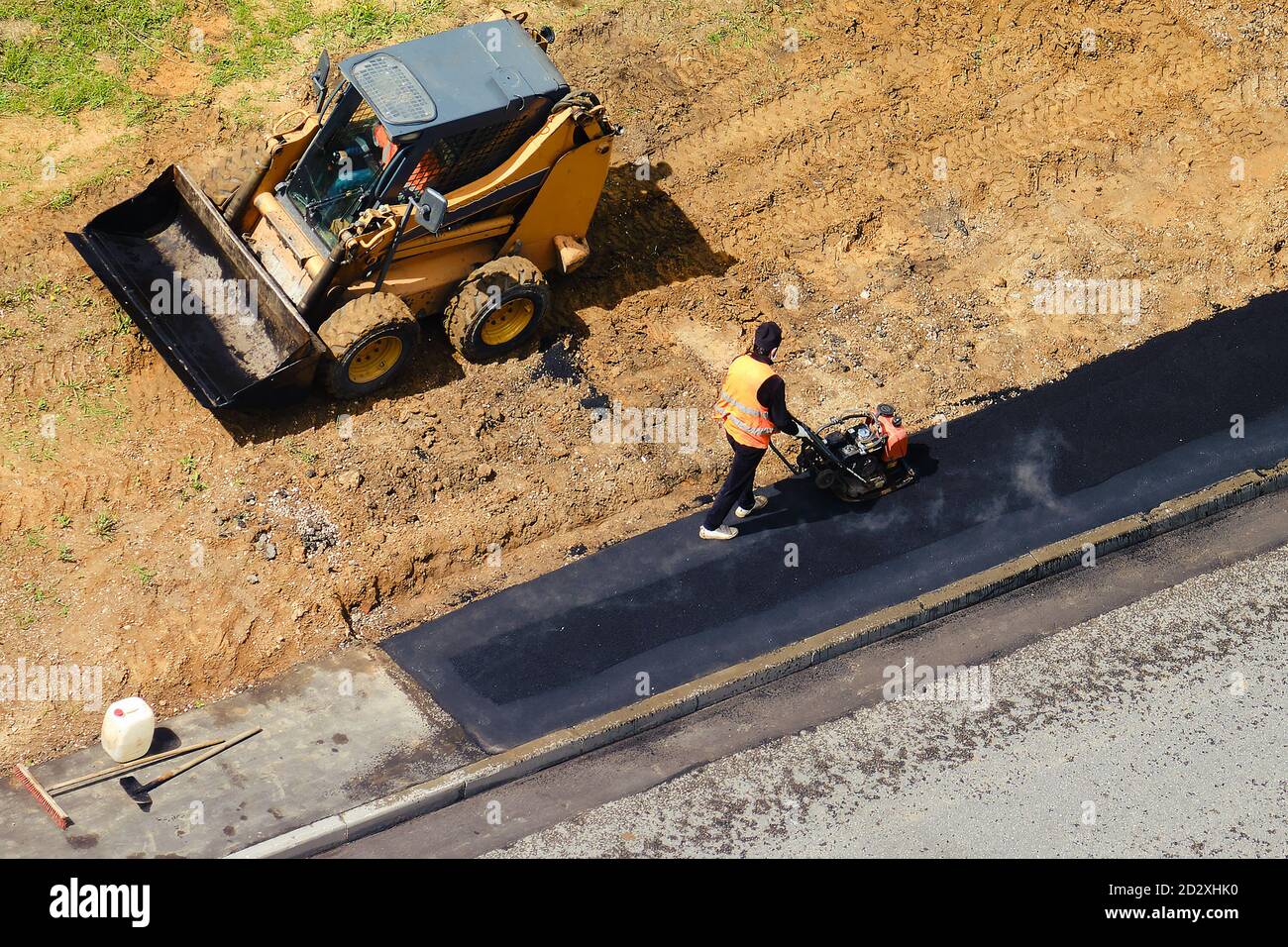 Road workers level the asphalt on the ground and lay it with a manual ...