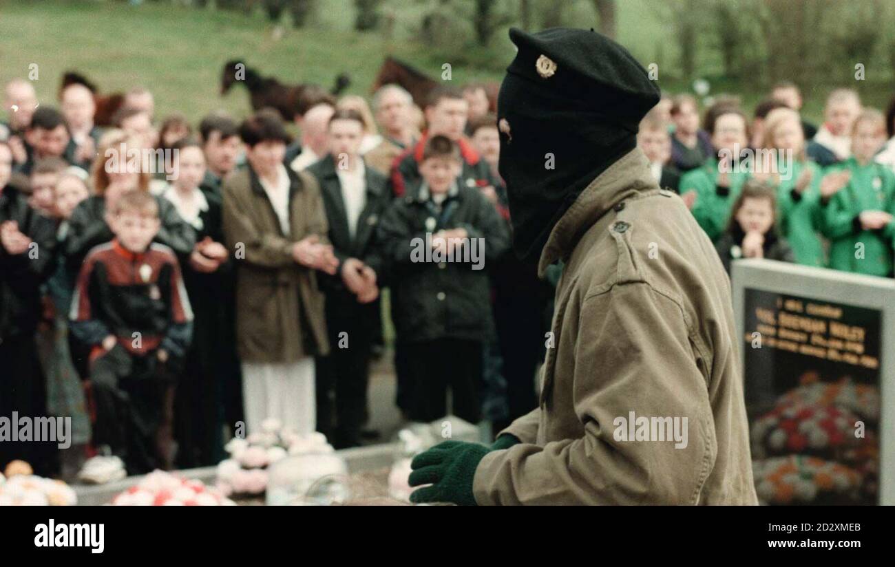 An IRA volunteer walks back into the crowd after reading a prepared ...