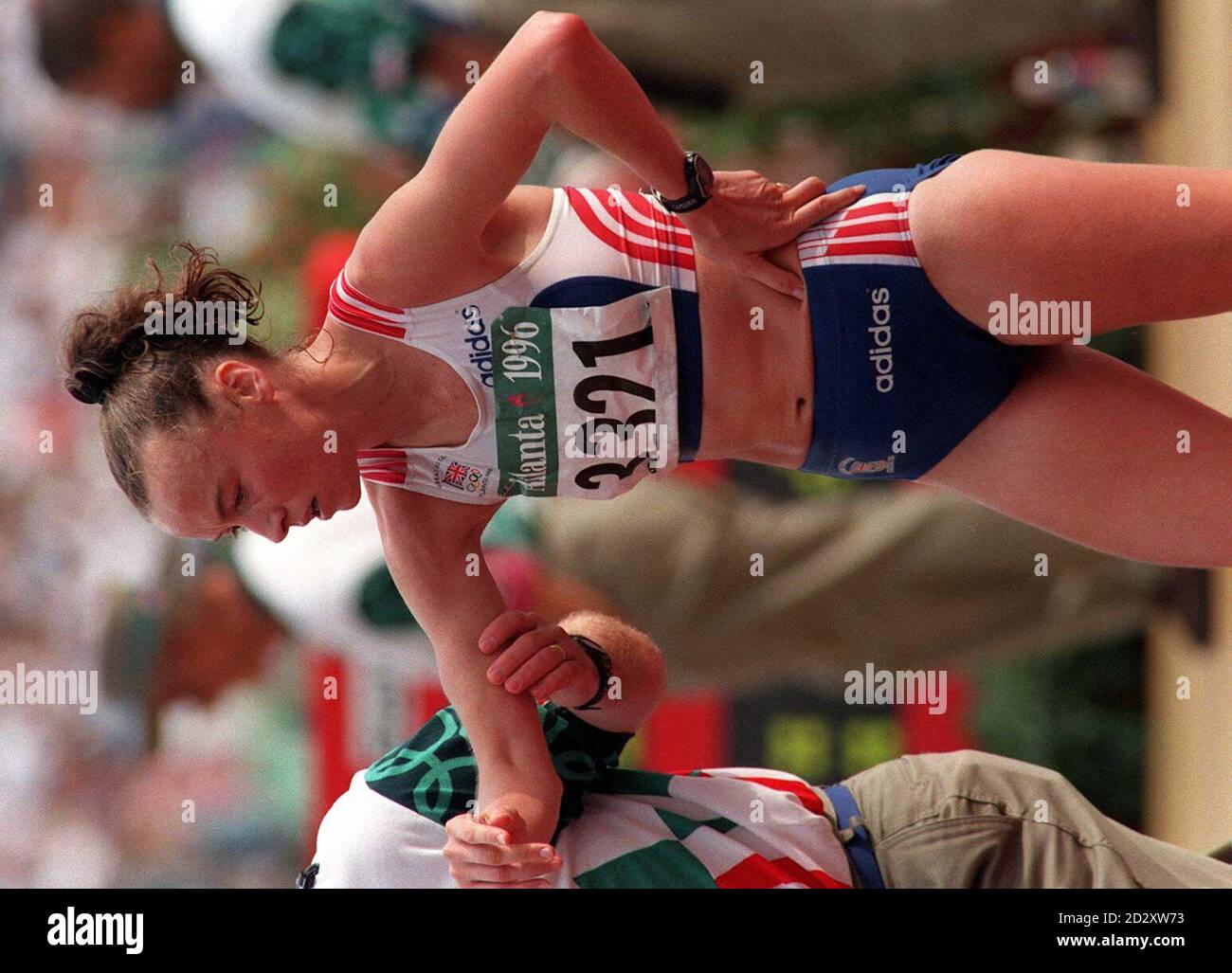 Britain's Liz McColgan is led off the track in the Olympic Stadium ...