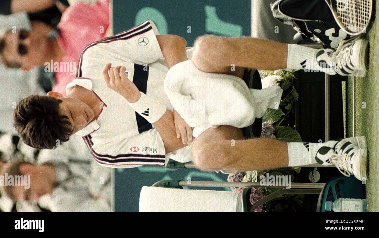 Tim Henman seems to have trouble with his elbow in a match against ...