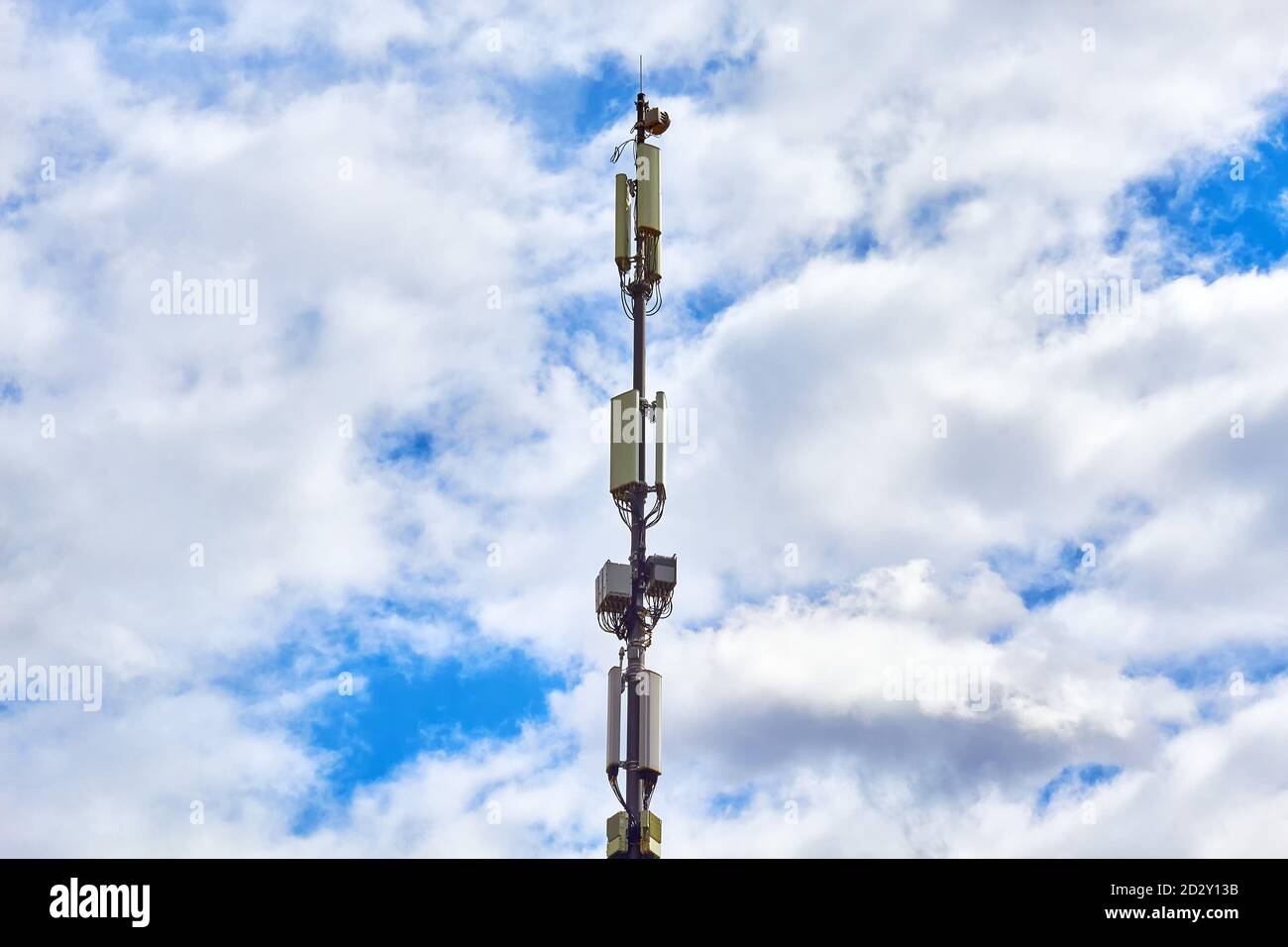 Cell tower against a cloudy sky. Base station of cellular operator ...