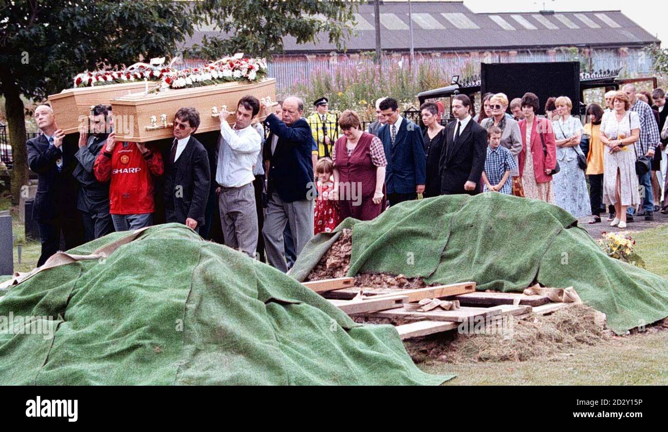 Pallbearers carry the coffins of Keith Ridding and Robert Boardman, to their final resting place ...