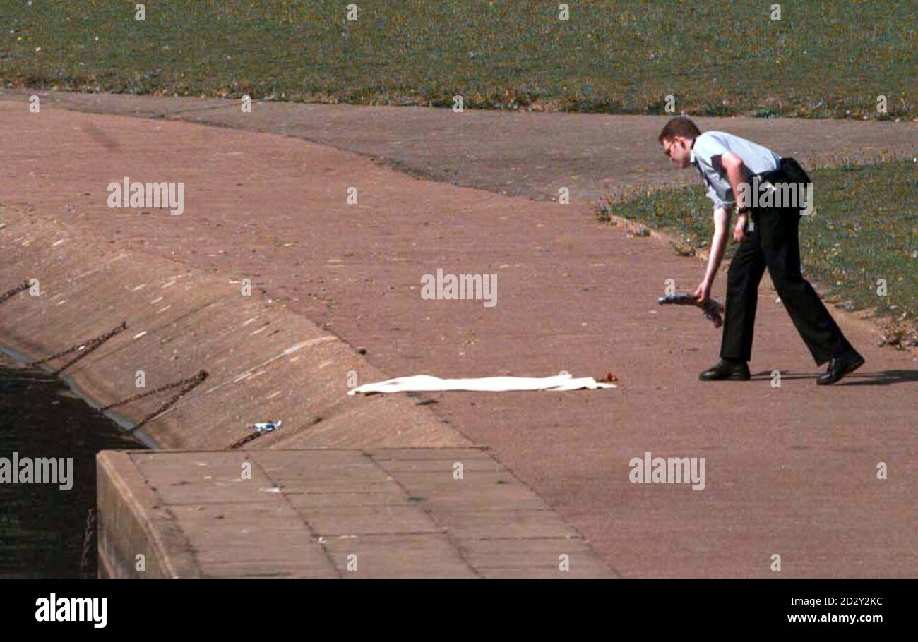 A policeman lays some flowers beside the lake at Fairlands Valley Park ...