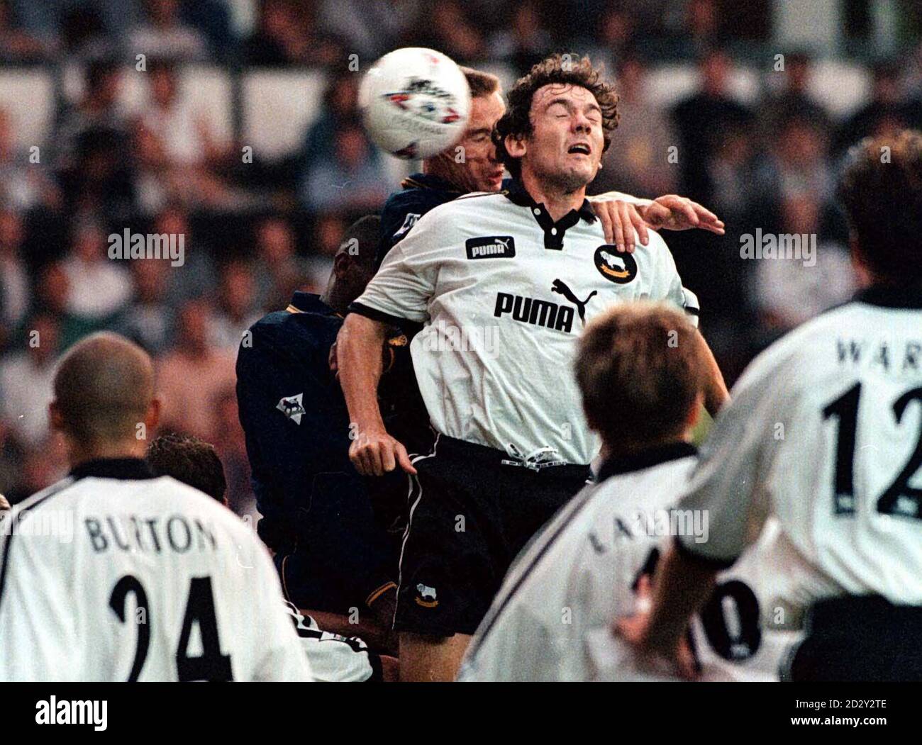 Wimbledon's Chris Perry (partially hidden) beats the Derby defence to ...