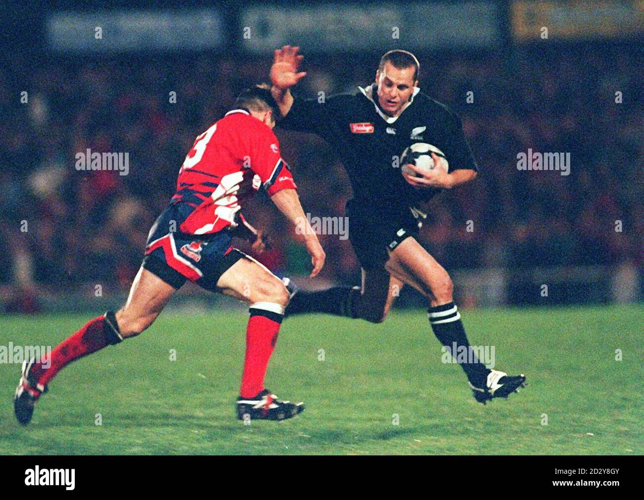 New Zealand's new wonder player Christian Cullen (right) hands off ...