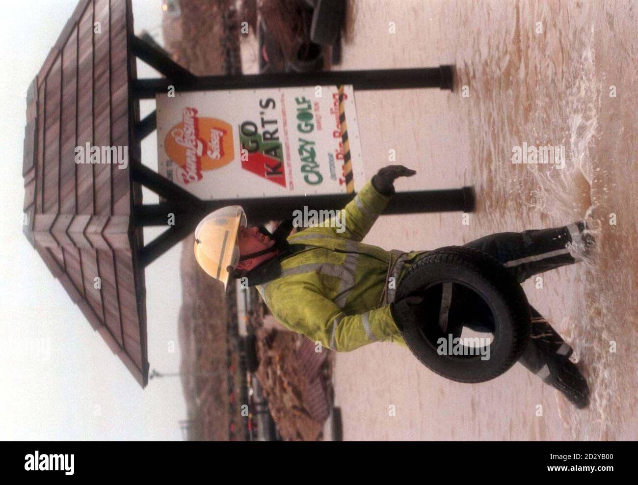 A fireman clears debris from a flooded caravan site in Selsey, West ...