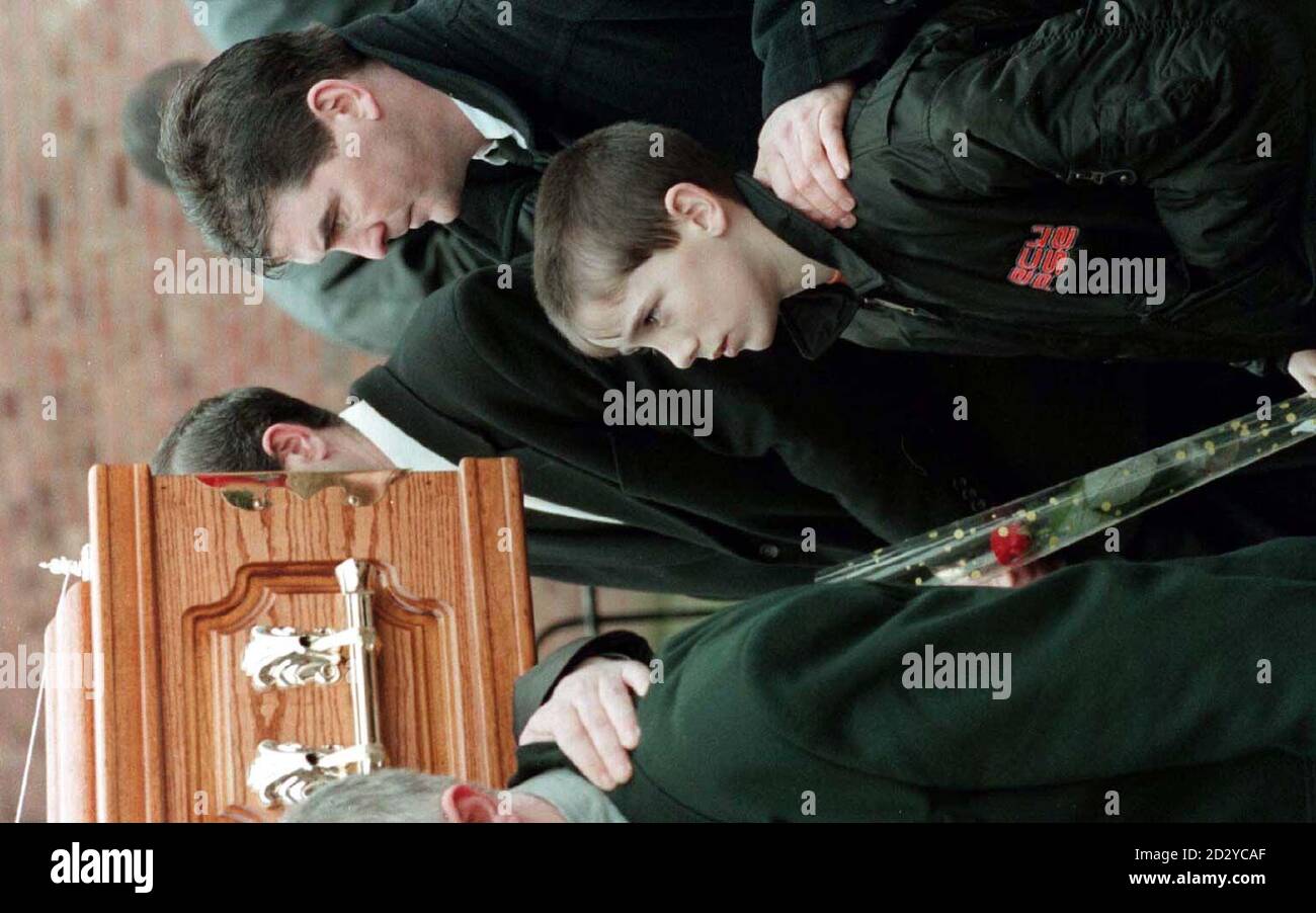 Sean McColgan (boy) looks up at his father's coffin as the funeral ...