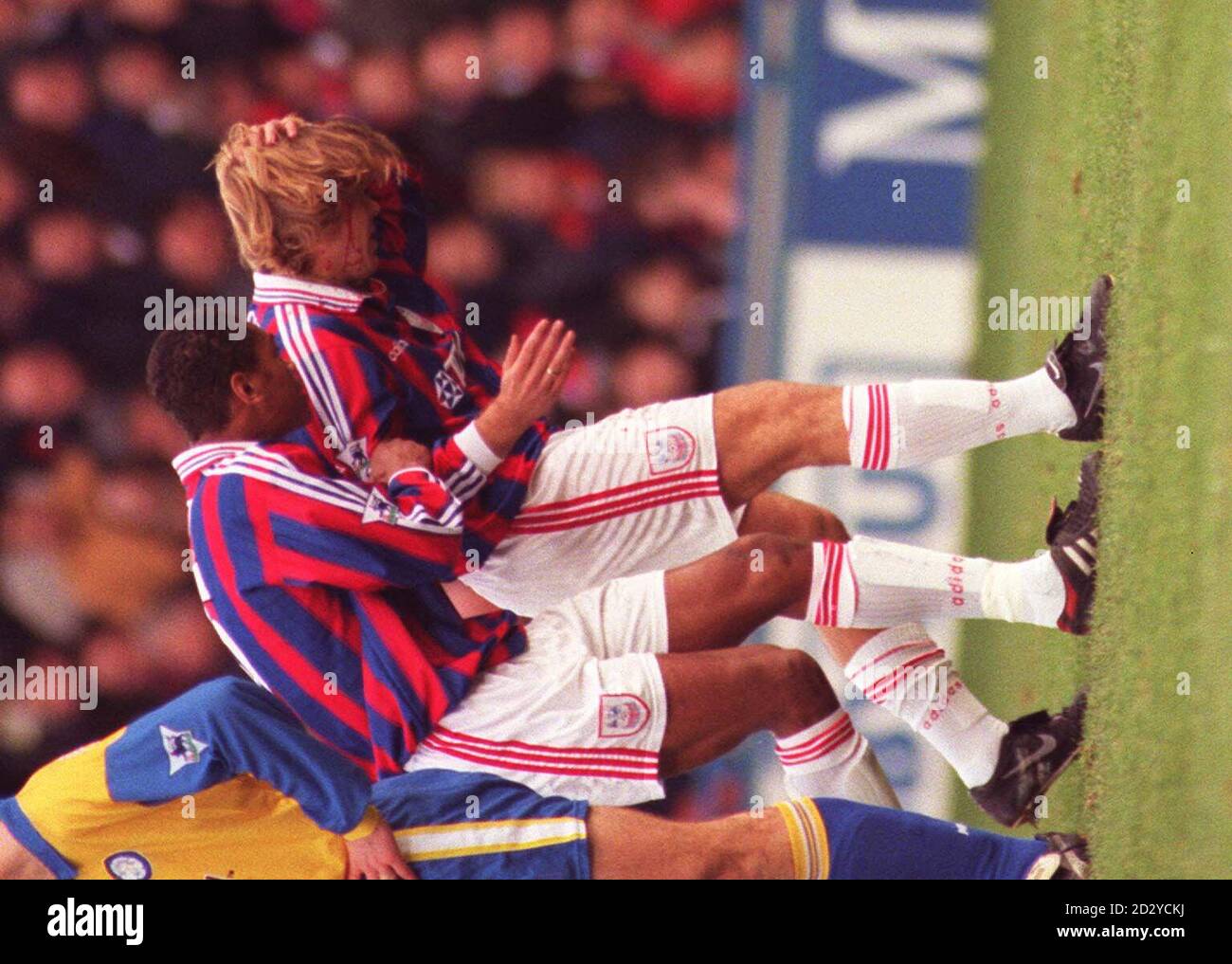 Crystal Palace player Tomas Brolin holds his head and is aided by ...