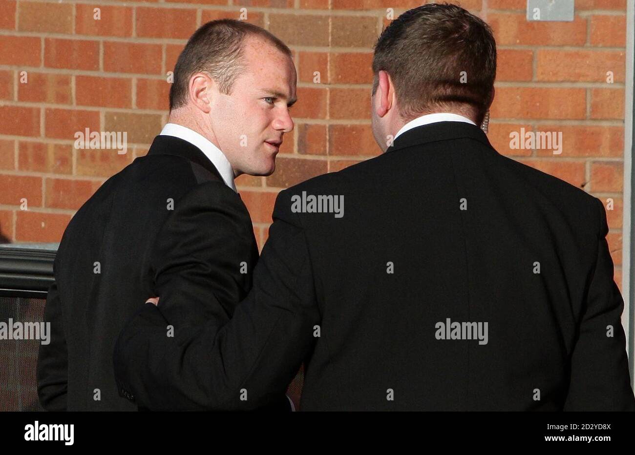 Manchester United's Wayne Rooney talks to a security guard as he ...