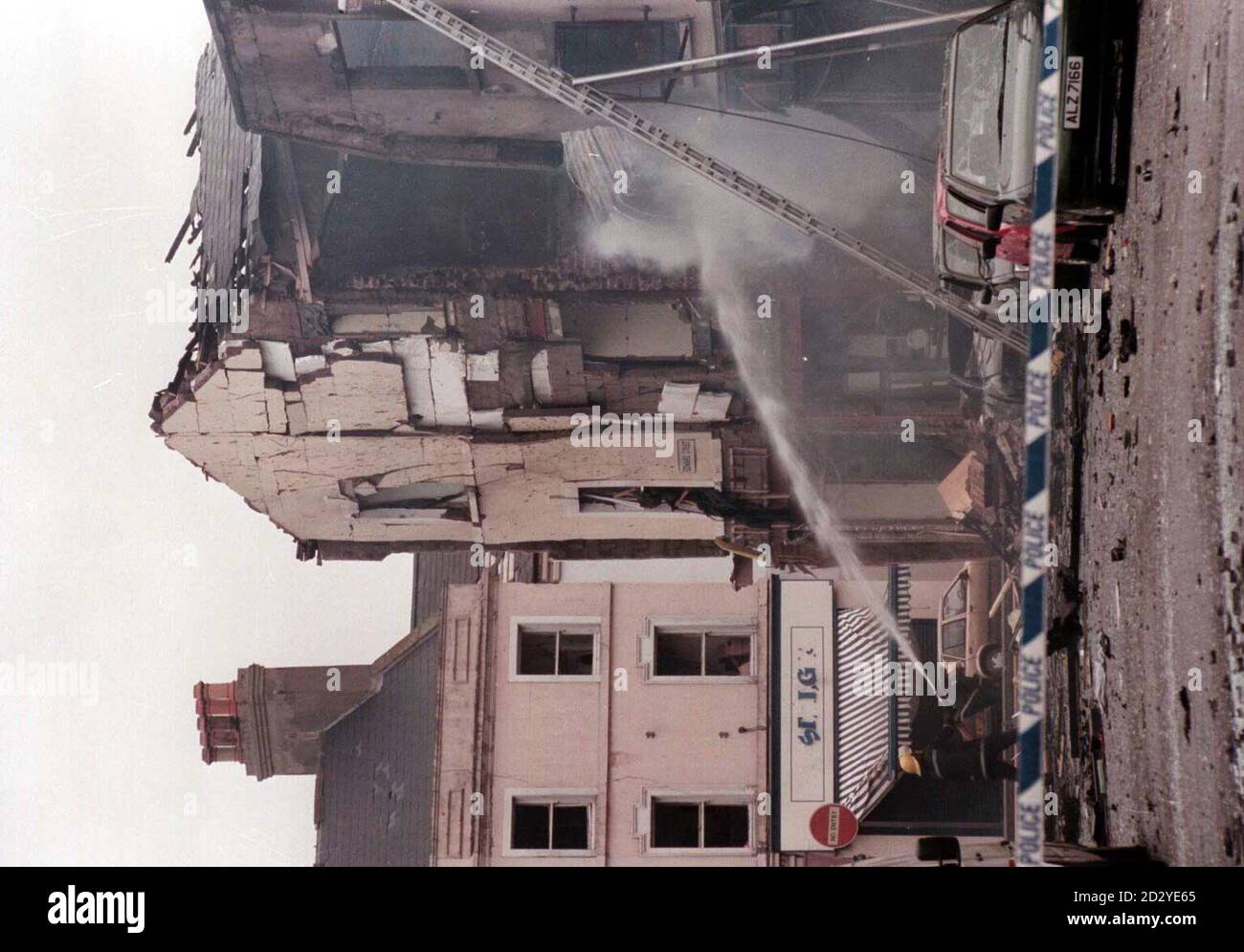 Fire officers dampen down buildings badly damaged when a car bomb ...