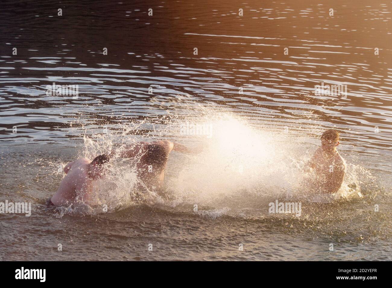 Adult men splashing in the water. People play in water. Silhouettes of ...