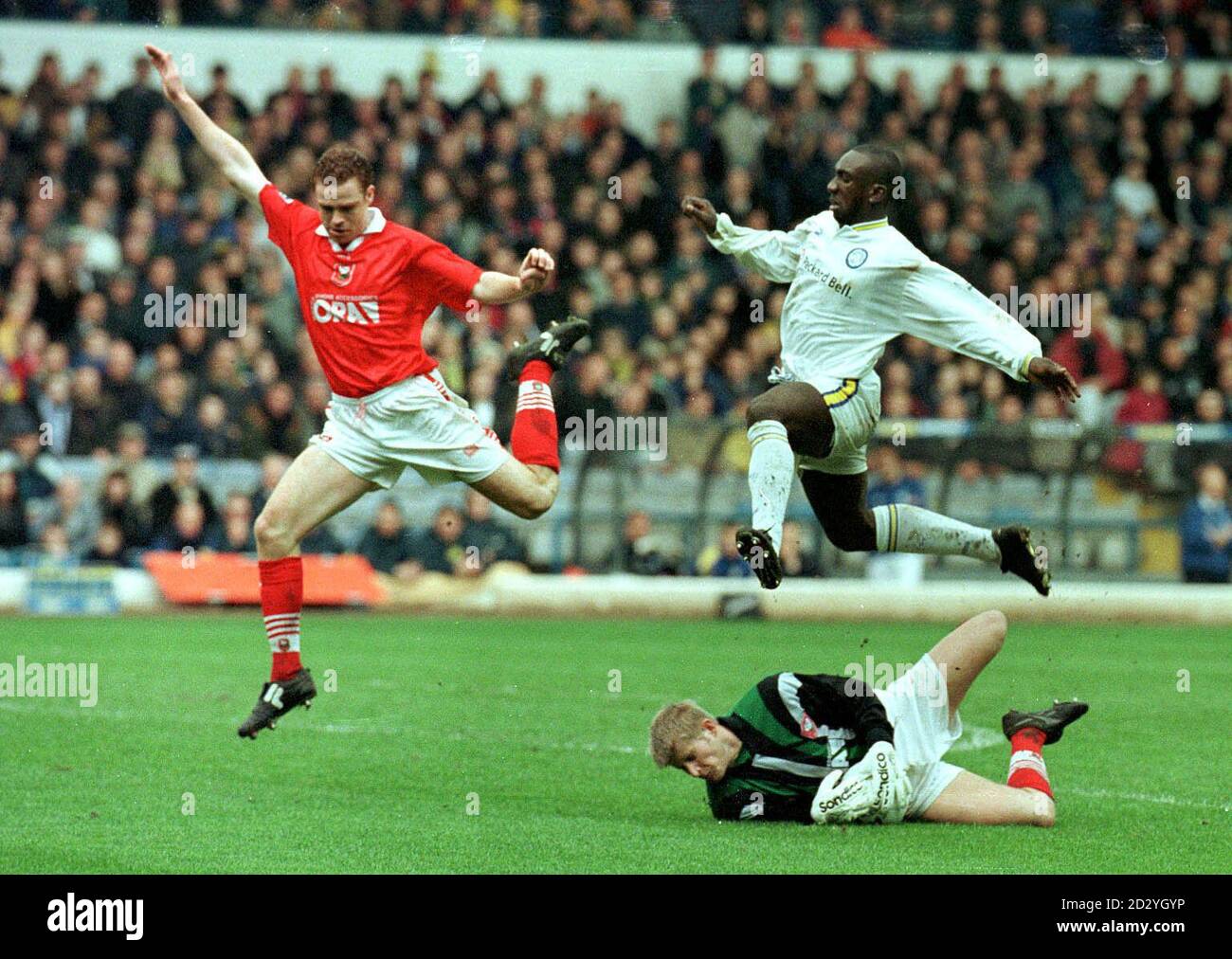 Barnsley's Adrian Moses (left) and Leeds Jimmy Floyd Hasselbaink jumps ...