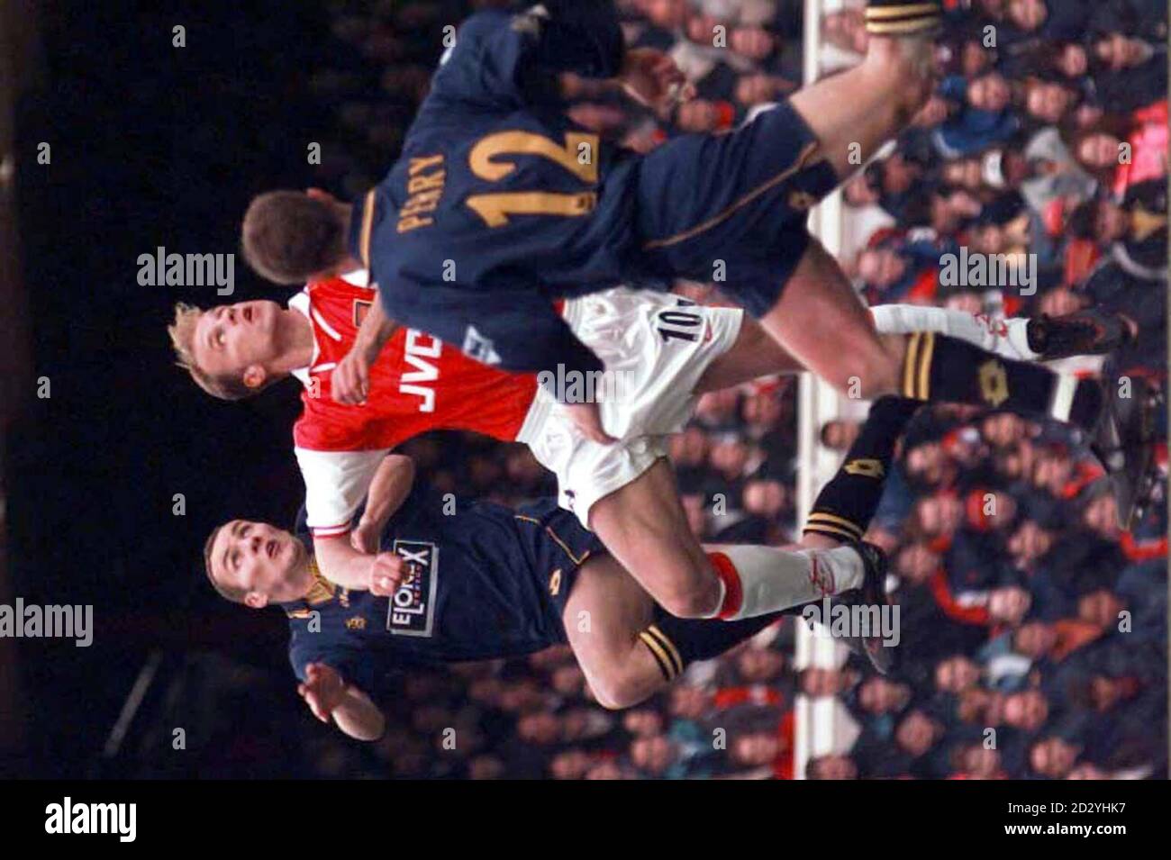 Arsenal striker Dennis Bergkamp (centre) battles with the Wimbledon ...