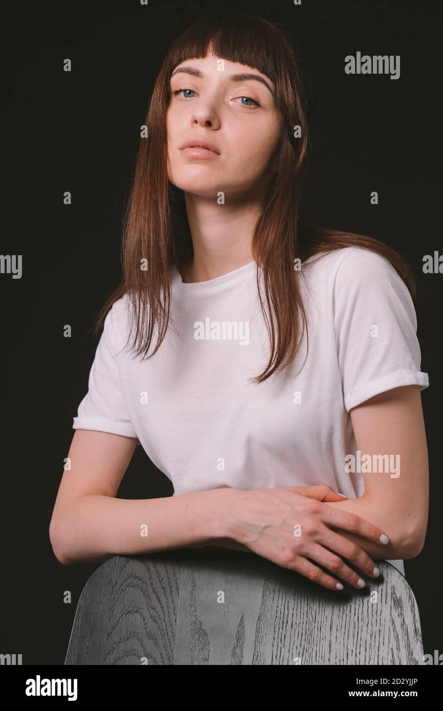 Portrait of a young woman leaning against chair hi-res stock ...