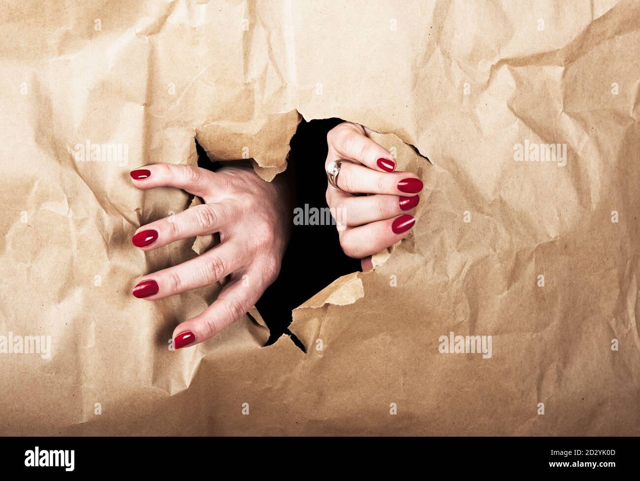 Female hands opening hole in brown paper. Breaking obstacles. Escape ...