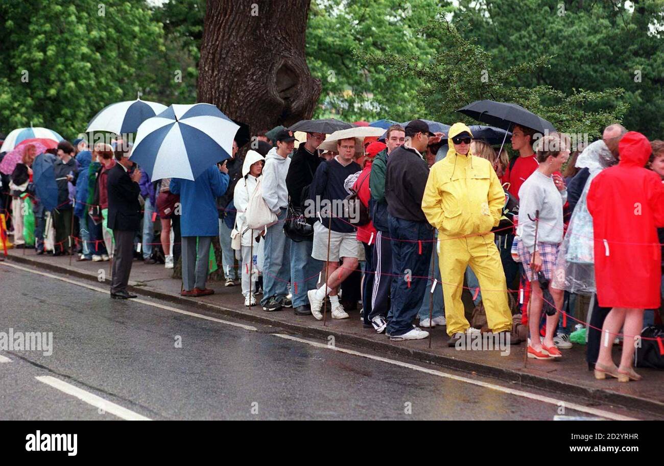 Wet weather wear is predominent in the queues at the Wimbledon ...