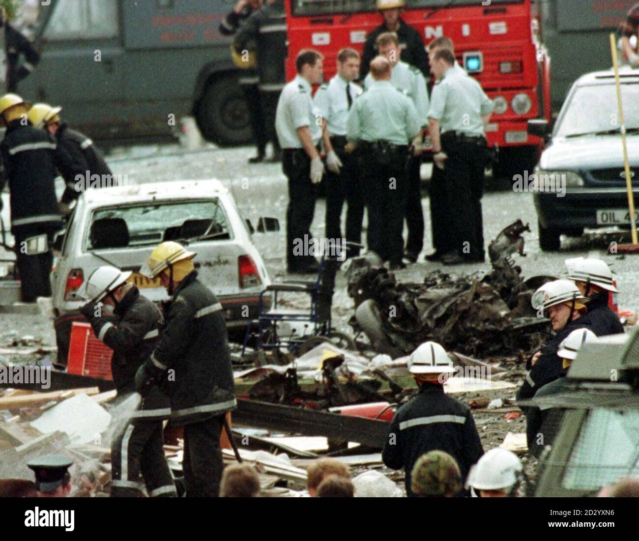 Royal Ulster Constabulary police officers and firefighters inspect the ...